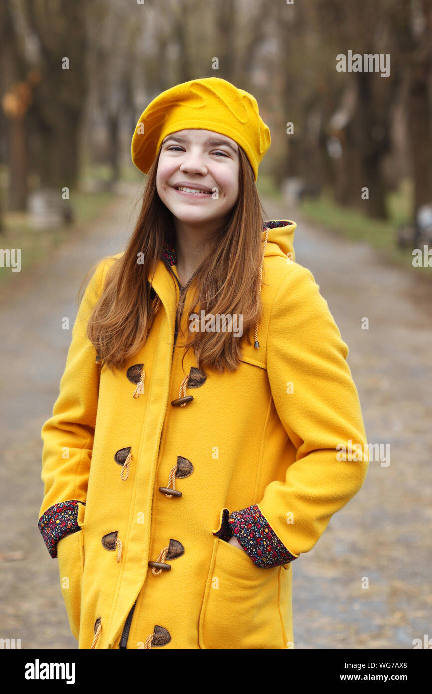 beautiful teenage girl in a yellow coat and beret portrait Stock Photo ...