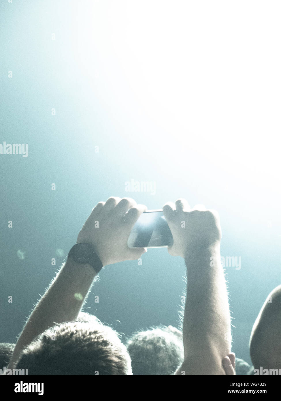 Concert crowd clapping in front of a bright stage Stock Photo - Alamy