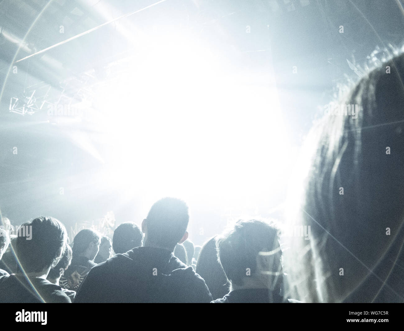 Concert crowd clapping in front of a bright stage Stock Photo - Alamy