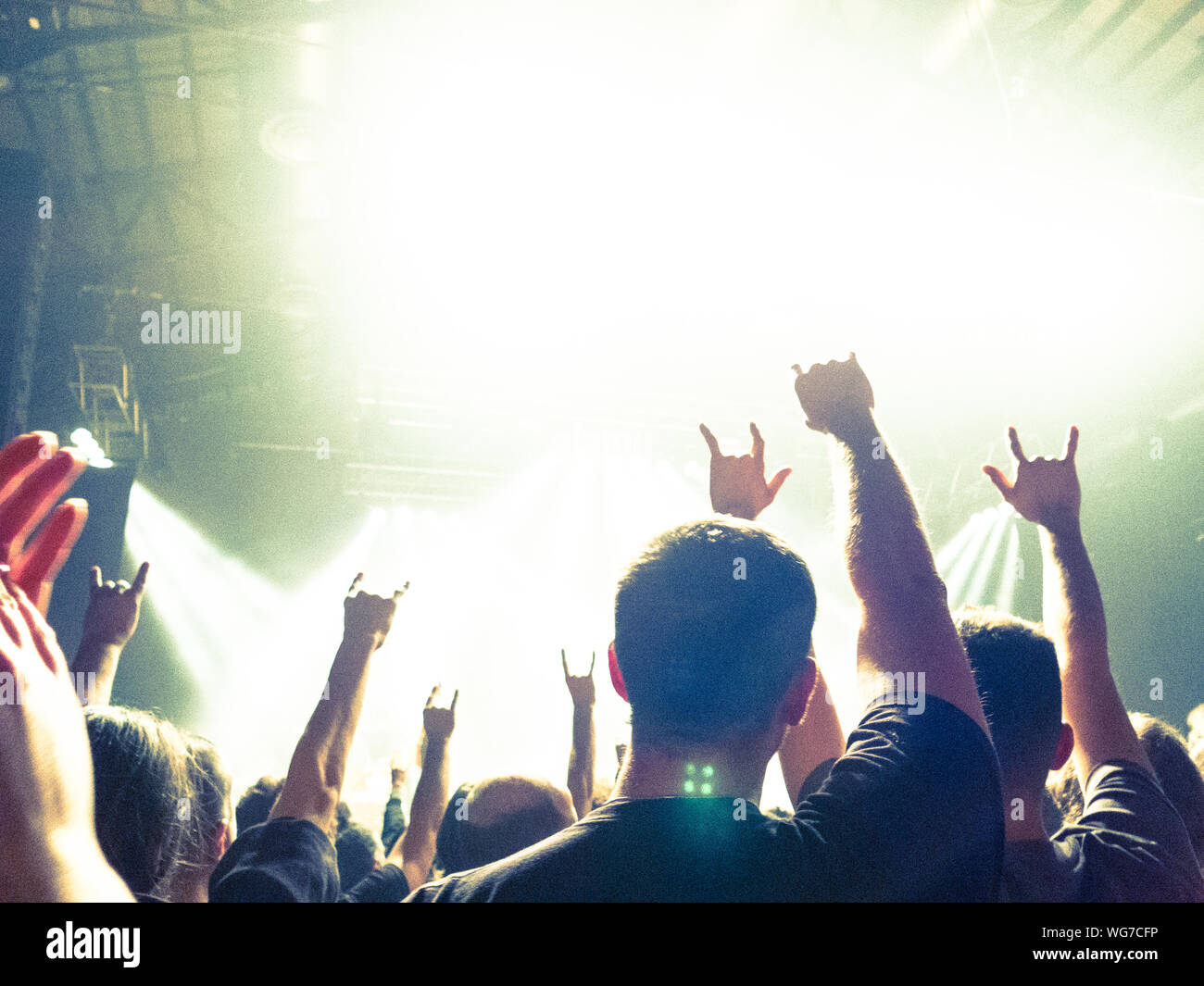 Concert crowd clapping in front of a bright stage Stock Photo - Alamy