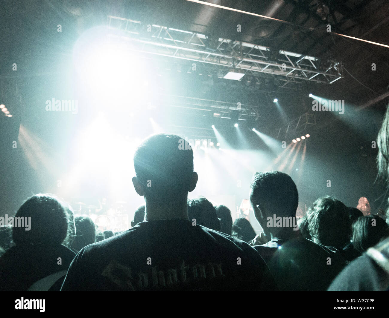 Concert crowd clapping in front of a bright stage Stock Photo - Alamy