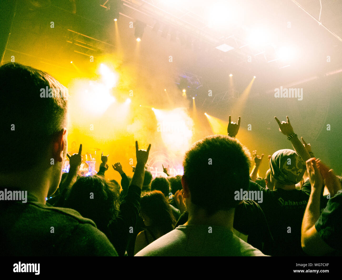 Concert crowd clapping in front of a bright stage Stock Photo - Alamy