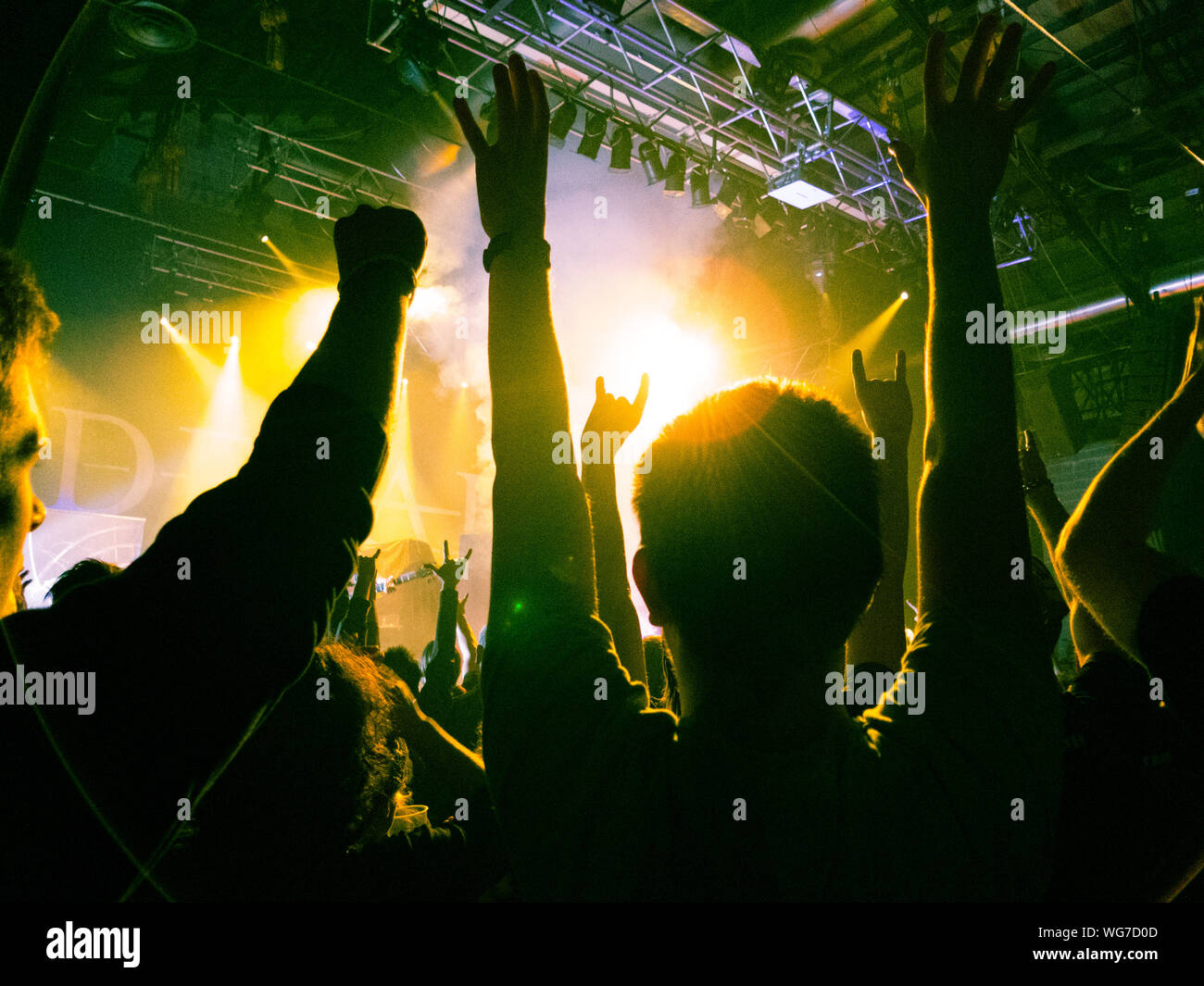 Concert crowd clapping in front of a bright stage Stock Photo - Alamy