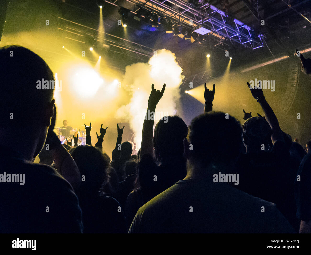 Concert crowd clapping in front of a bright stage Stock Photo - Alamy