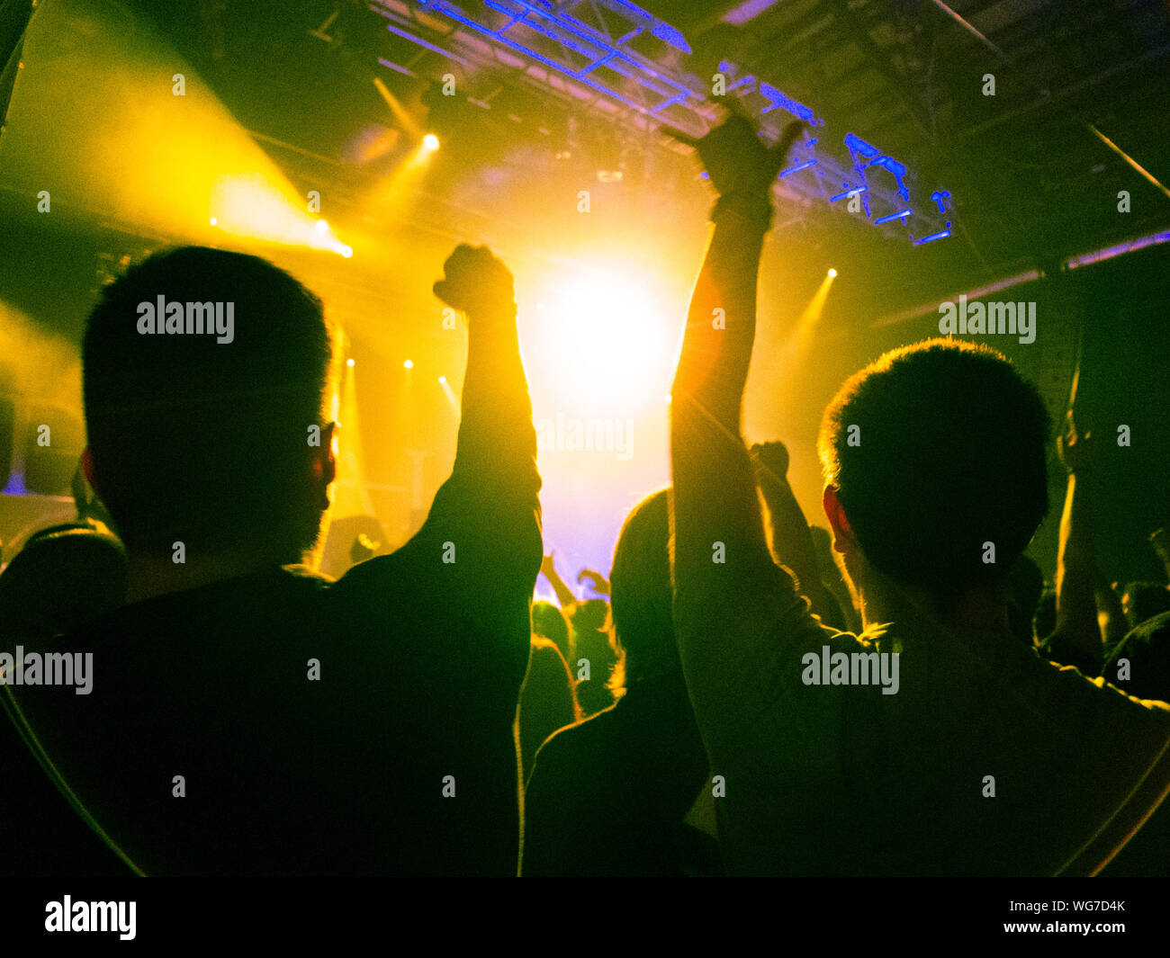Concert crowd clapping in front of a bright stage Stock Photo - Alamy
