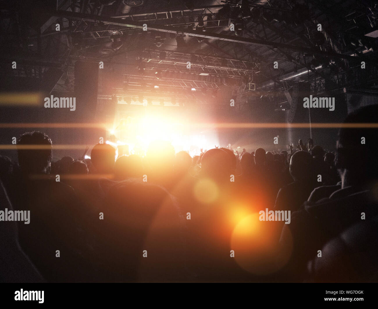 Concert crowd clapping in front of a bright stage Stock Photo - Alamy