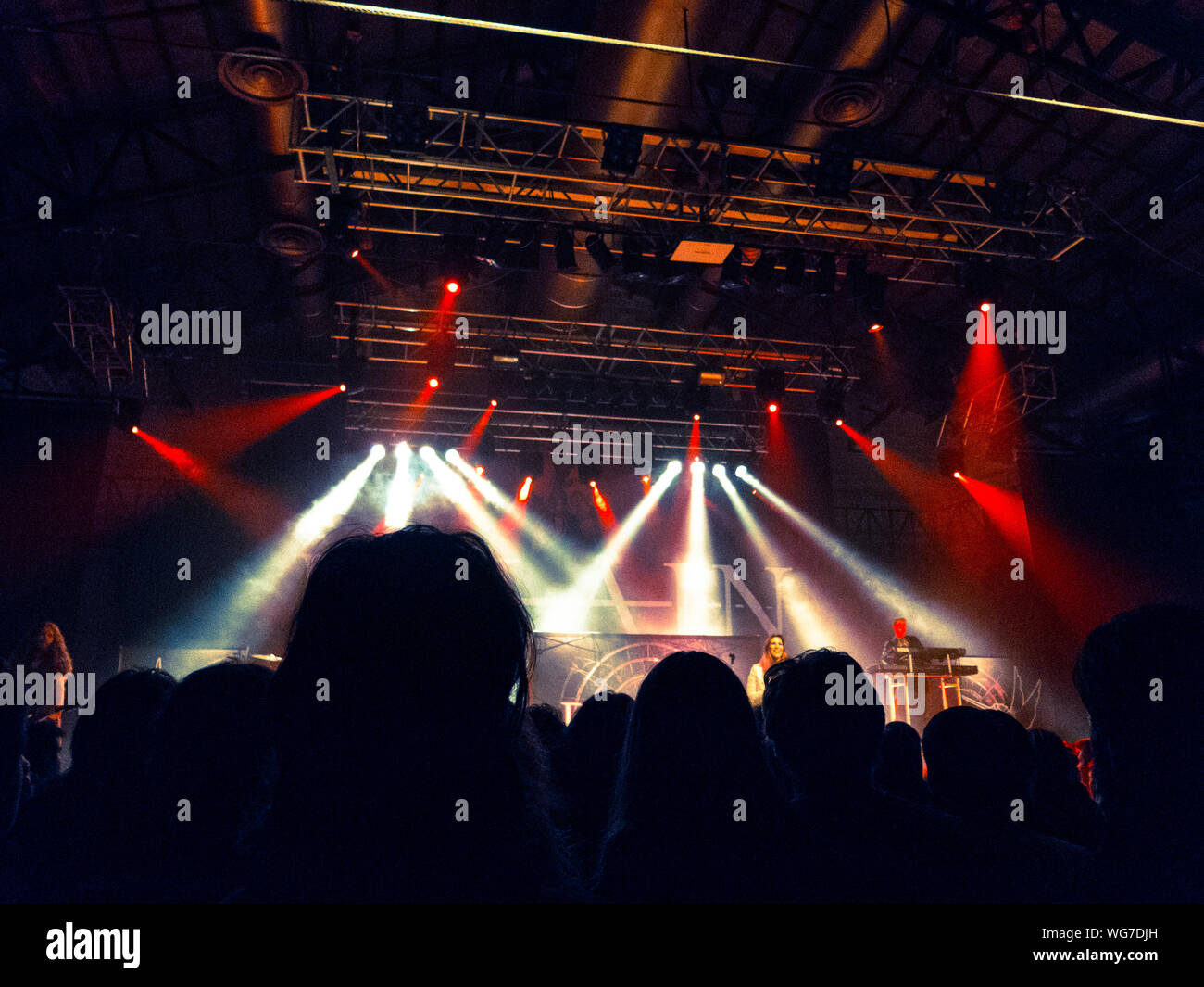 Concert crowd clapping in front of a bright stage Stock Photo - Alamy