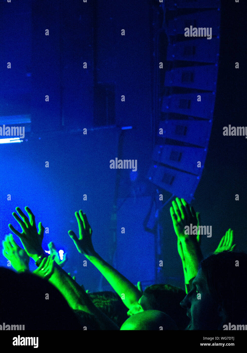 Concert crowd clapping in front of a bright stage Stock Photo - Alamy