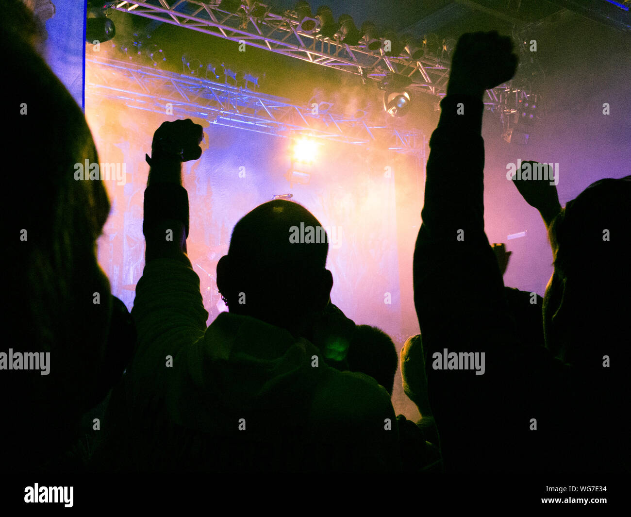 Concert crowd clapping in front of a bright stage Stock Photo - Alamy