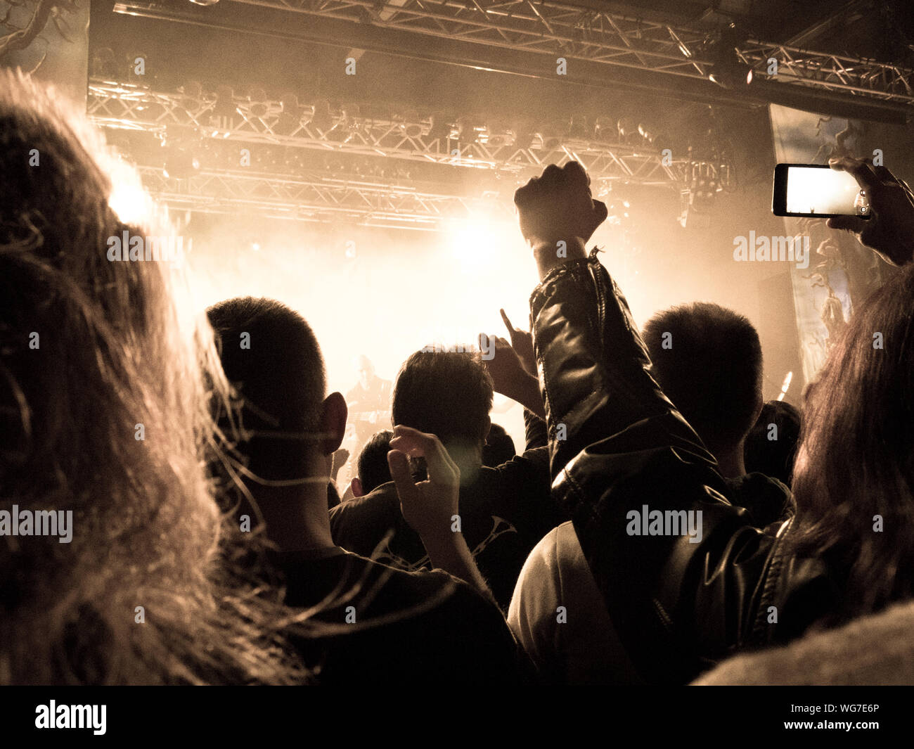 Concert crowd clapping in front of a bright stage Stock Photo - Alamy