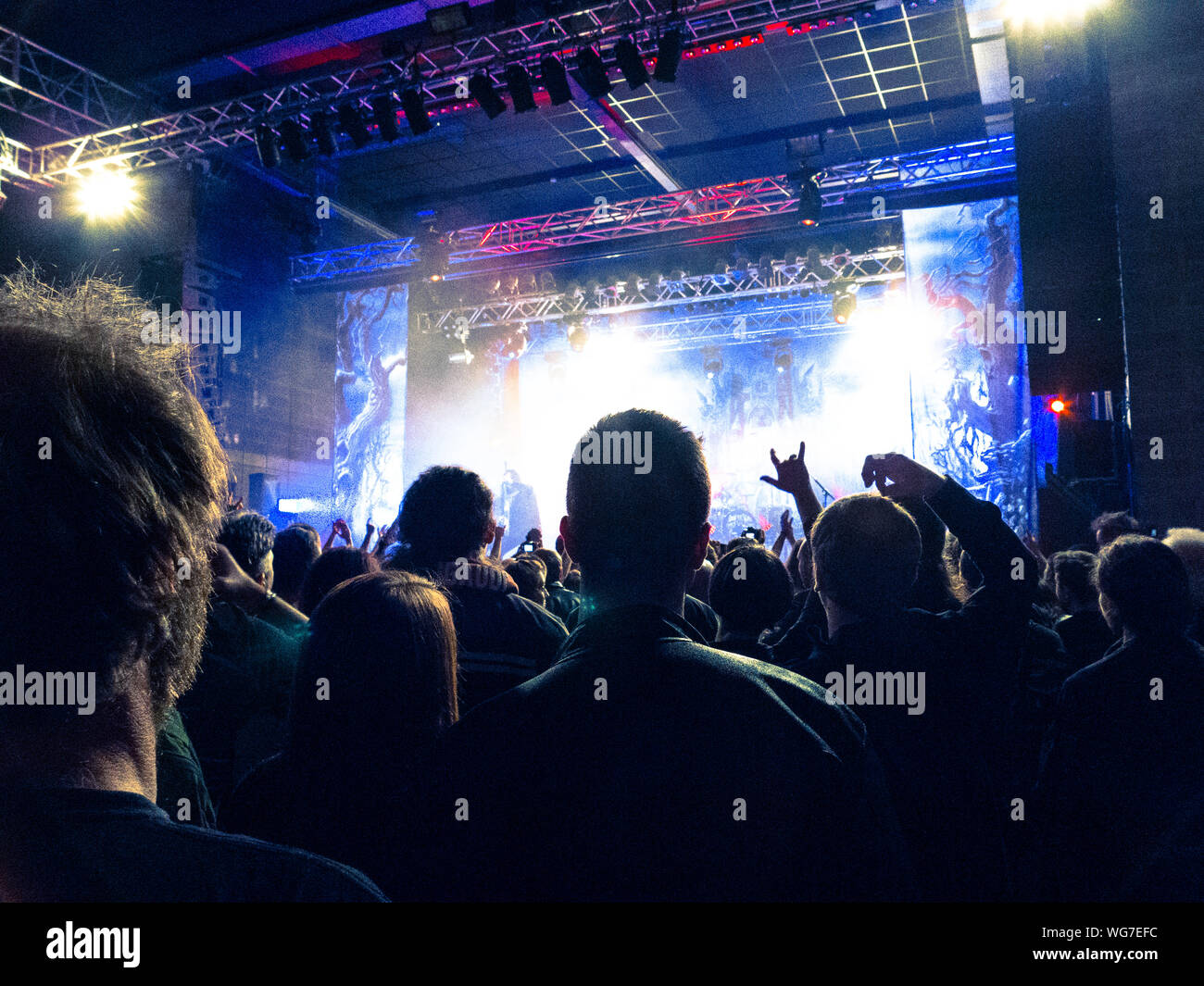 Concert crowd clapping in front of a bright stage Stock Photo - Alamy