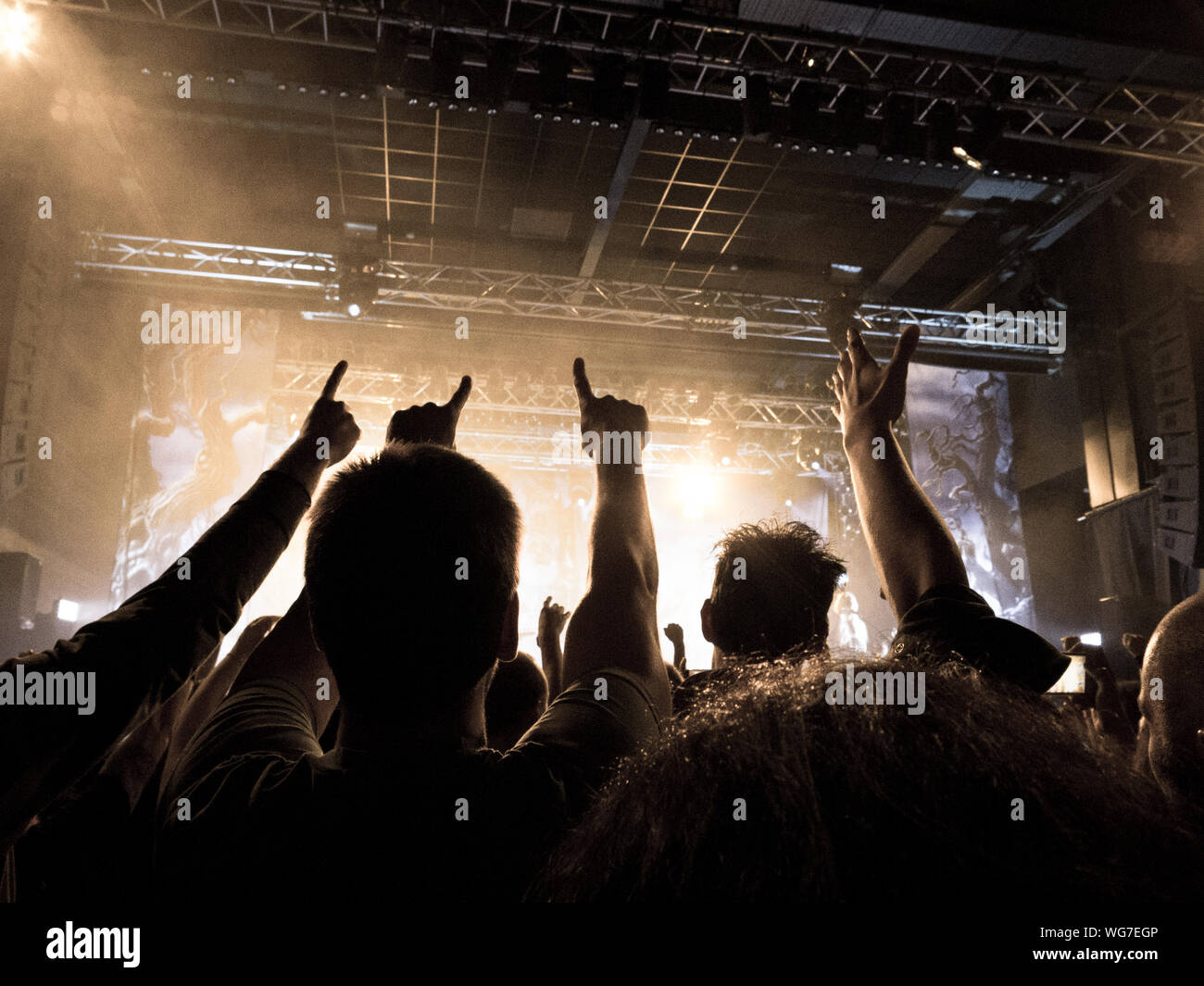 Concert crowd clapping in front of a bright stage Stock Photo - Alamy