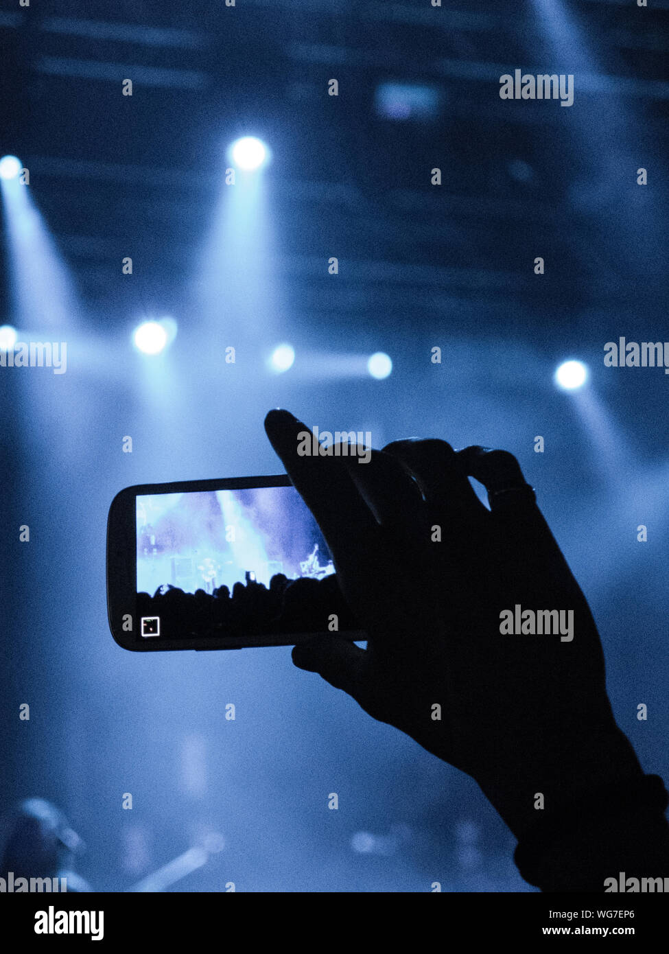 Concert crowd clapping in front of a bright stage Stock Photo - Alamy