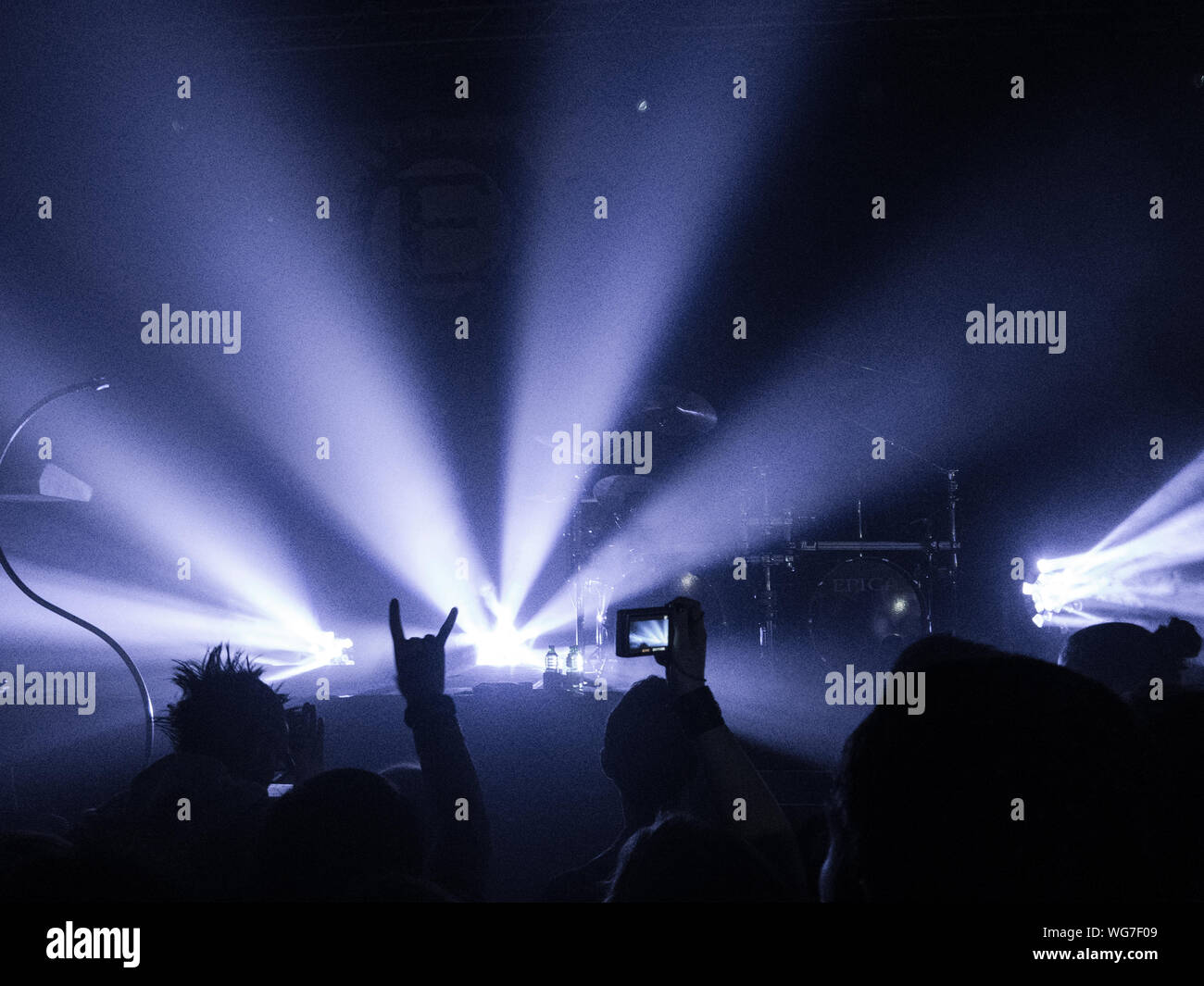 Concert crowd clapping in front of a bright stage Stock Photo - Alamy