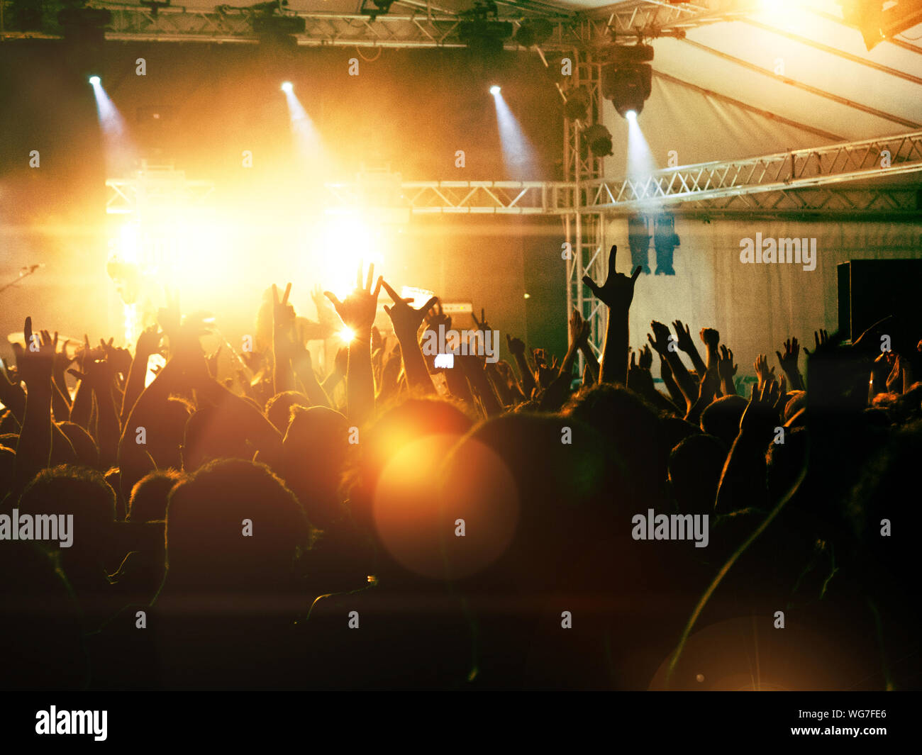 Concert crowd clapping in front of a bright stage Stock Photo - Alamy