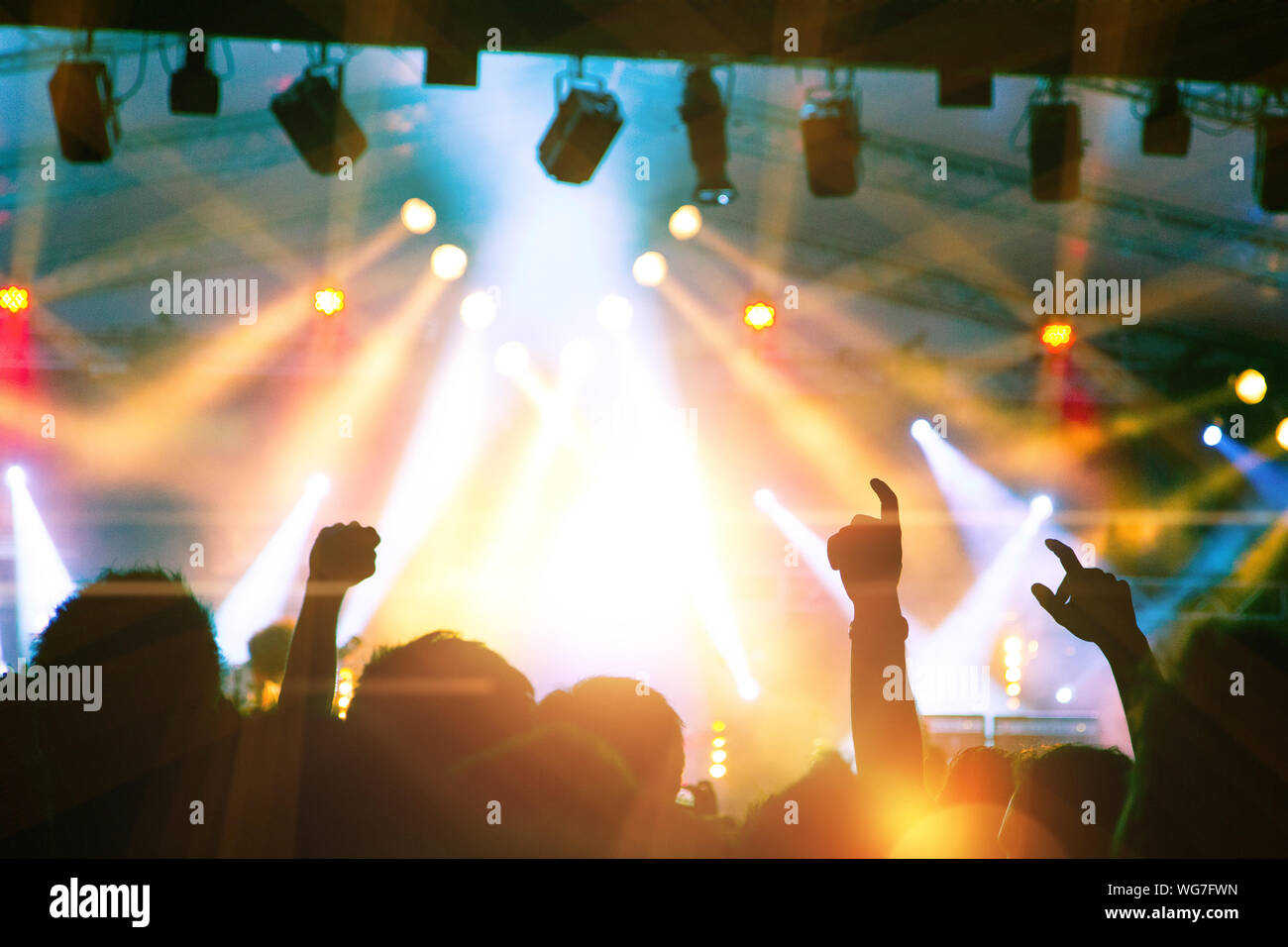 Concert crowd clapping in front of a bright stage Stock Photo - Alamy