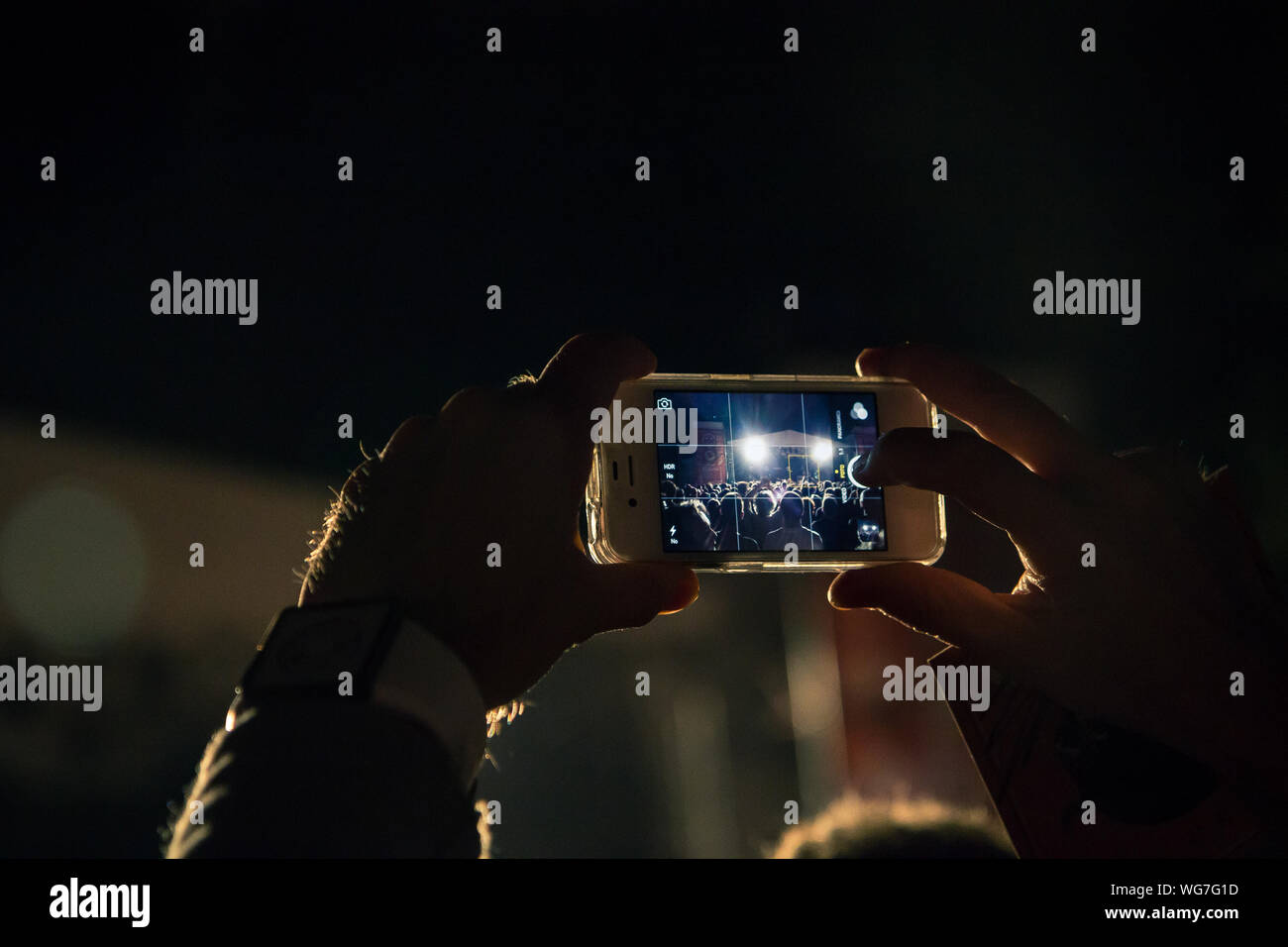 Concert crowd clapping in front of a bright stage Stock Photo - Alamy