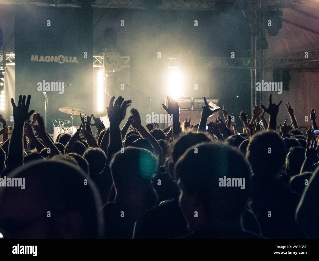 Concert crowd clapping in front of a bright stage Stock Photo - Alamy