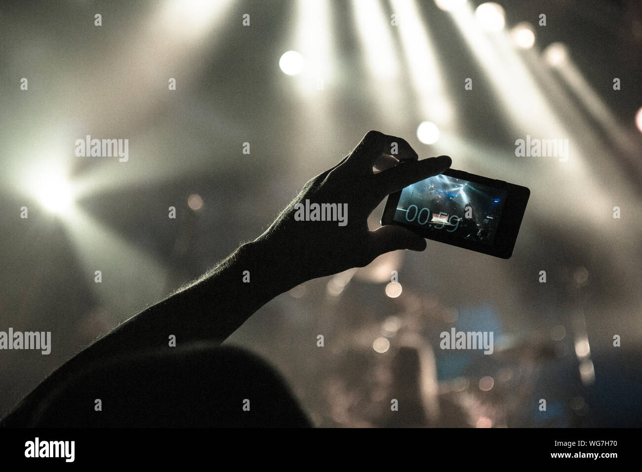 Concert crowd clapping in front of a bright stage Stock Photo - Alamy