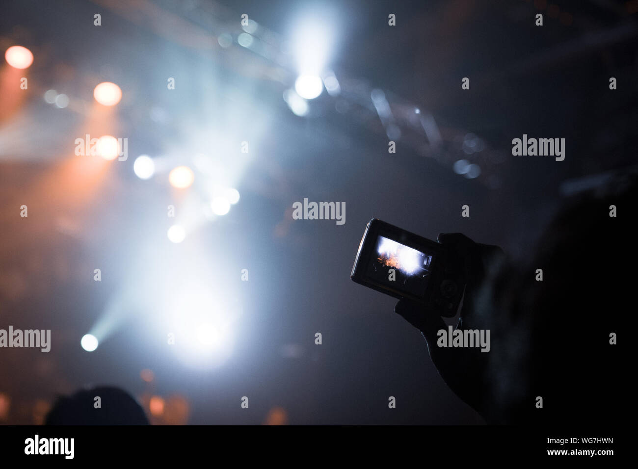Concert crowd clapping in front of a bright stage Stock Photo - Alamy