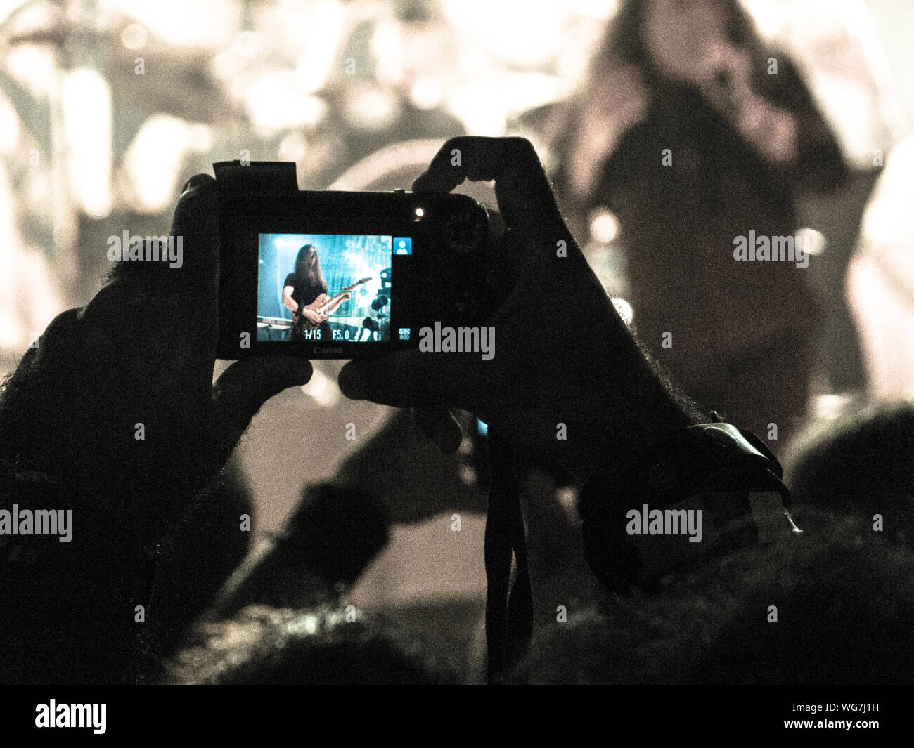 Concert crowd clapping in front of a bright stage Stock Photo - Alamy