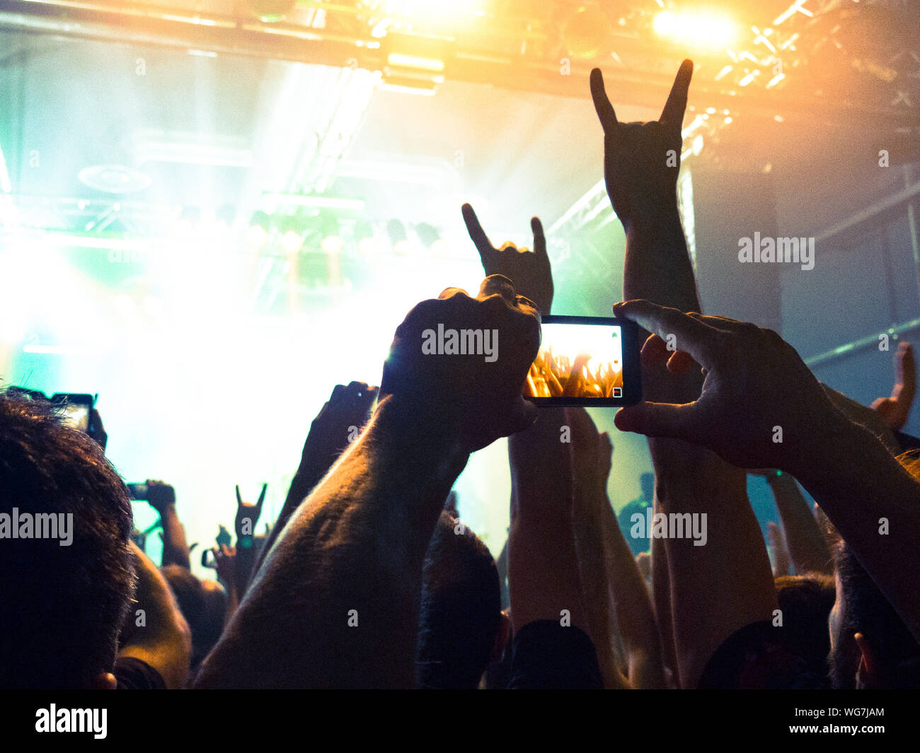Concert crowd clapping in front of a bright stage Stock Photo - Alamy