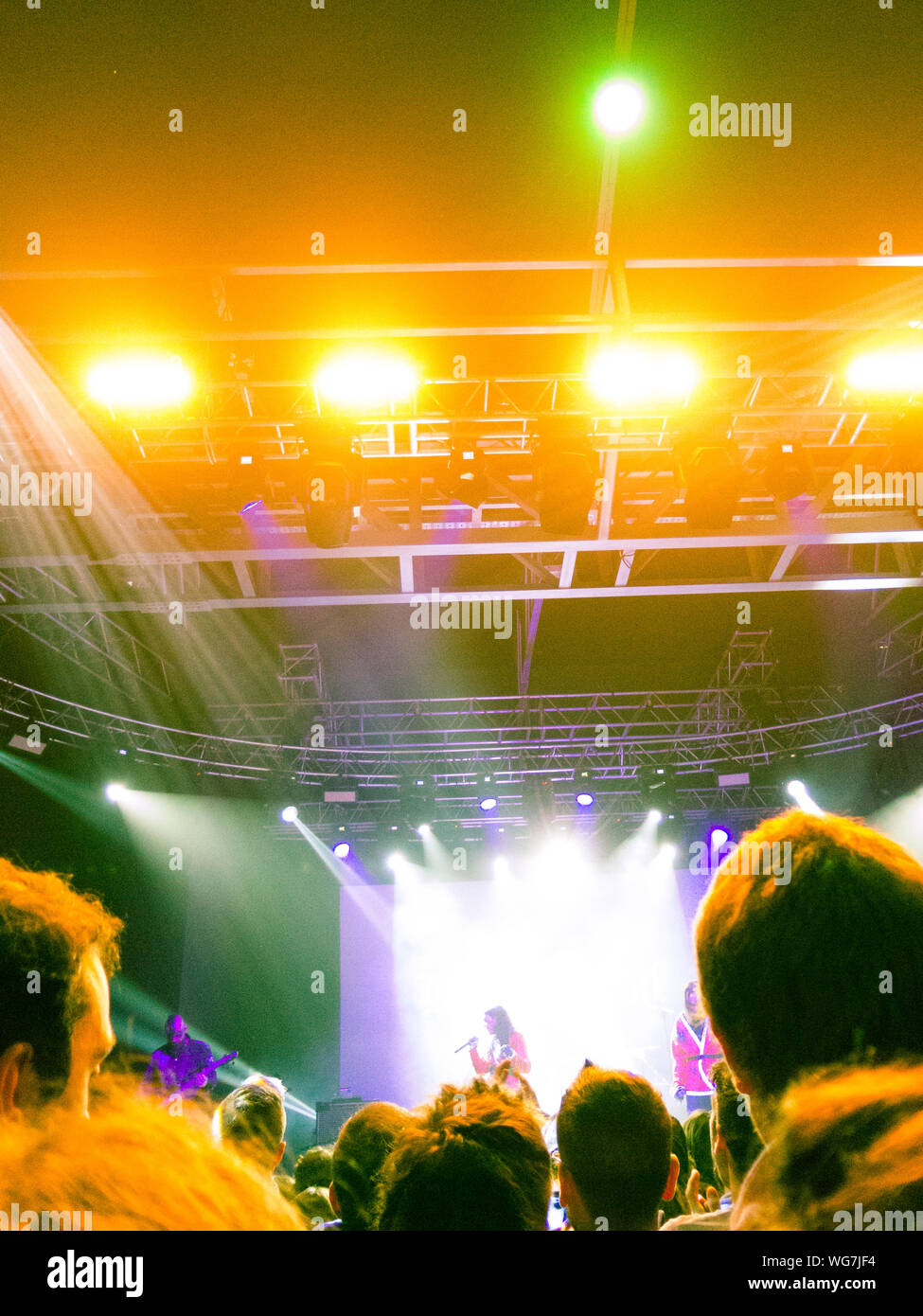 Concert crowd clapping in front of a bright stage Stock Photo - Alamy