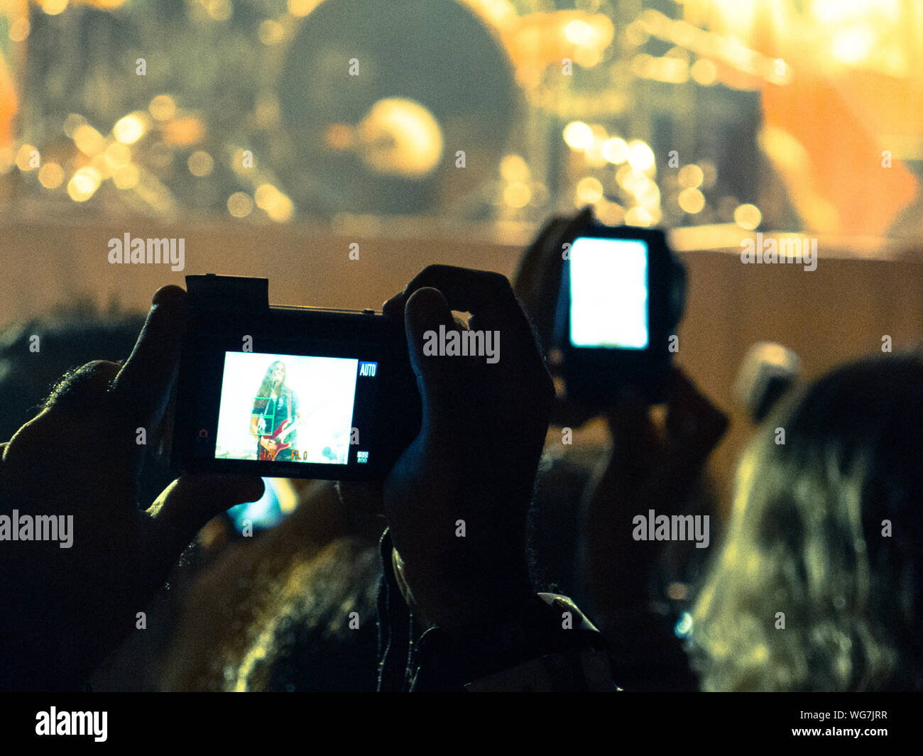 Concert crowd clapping in front of a bright stage Stock Photo - Alamy