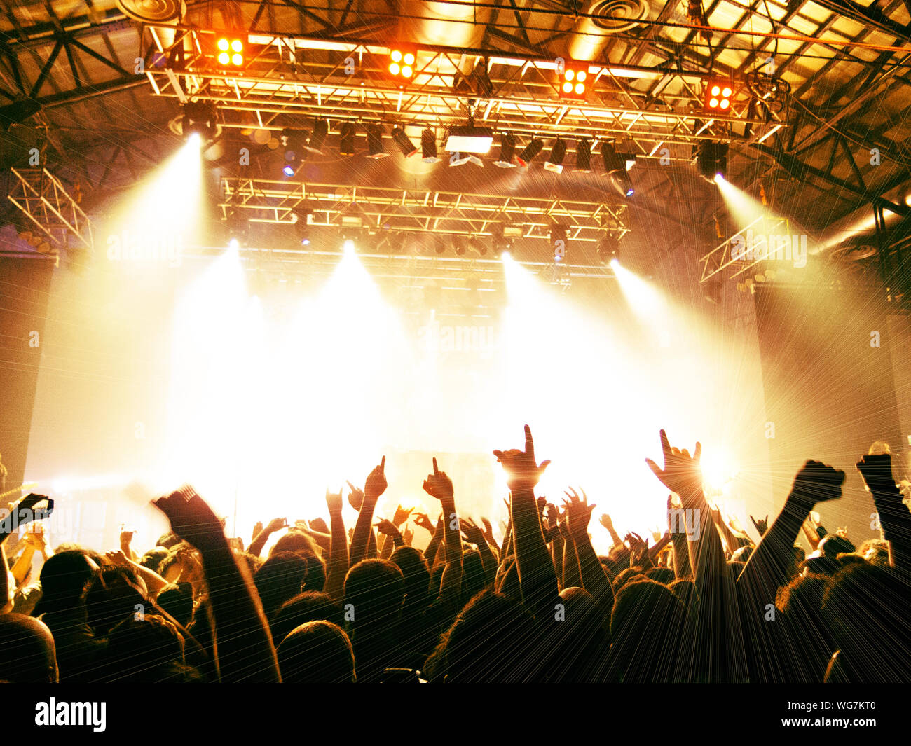 Concert crowd clapping in front of a bright stage Stock Photo - Alamy