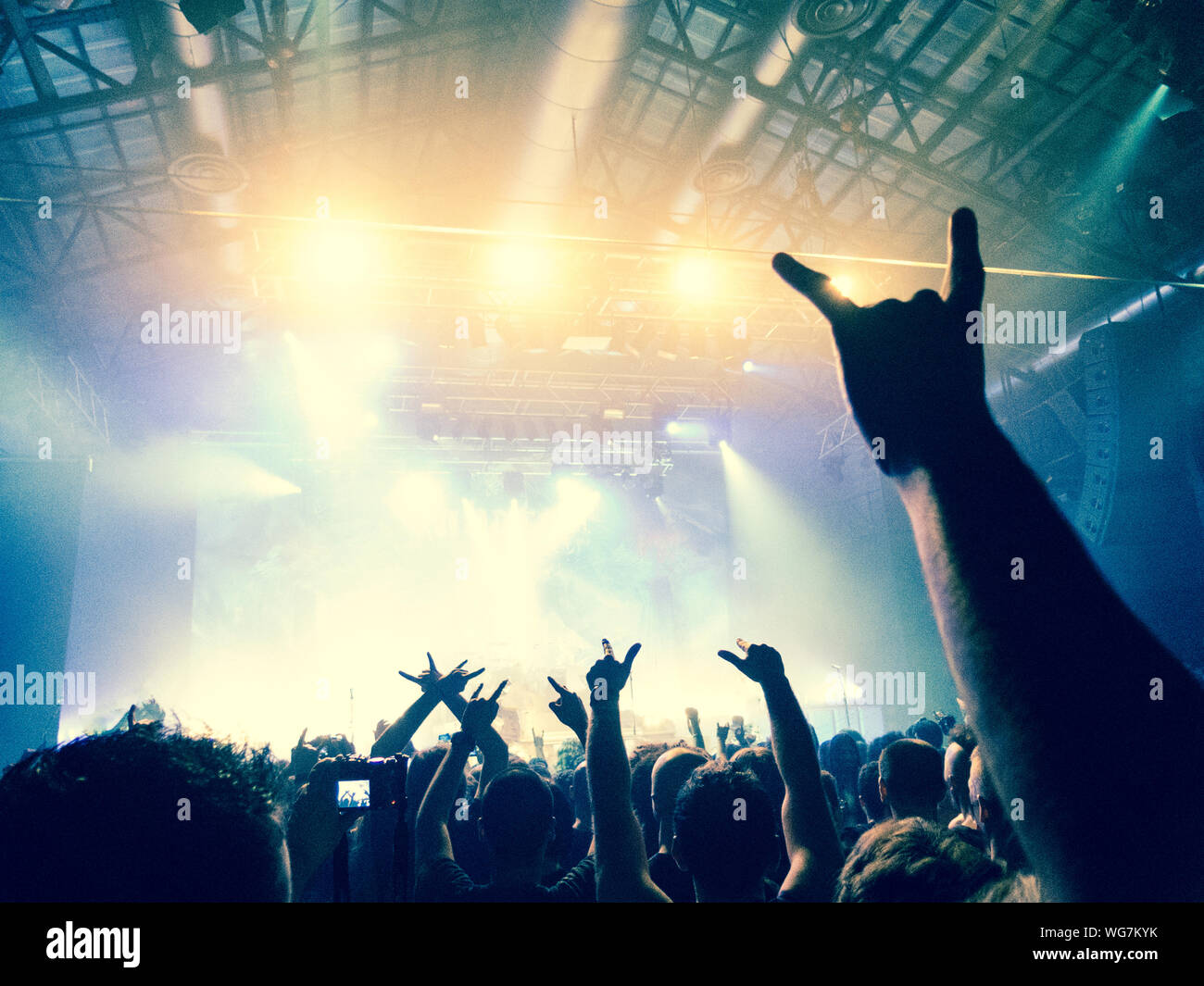 Concert crowd clapping in front of a bright stage Stock Photo - Alamy