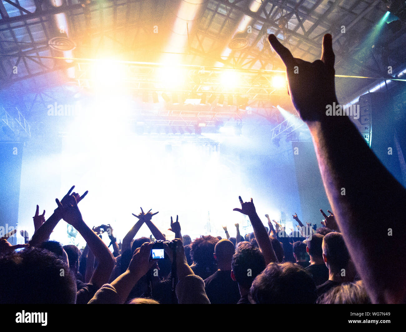 Concert crowd clapping in front of a bright stage Stock Photo - Alamy