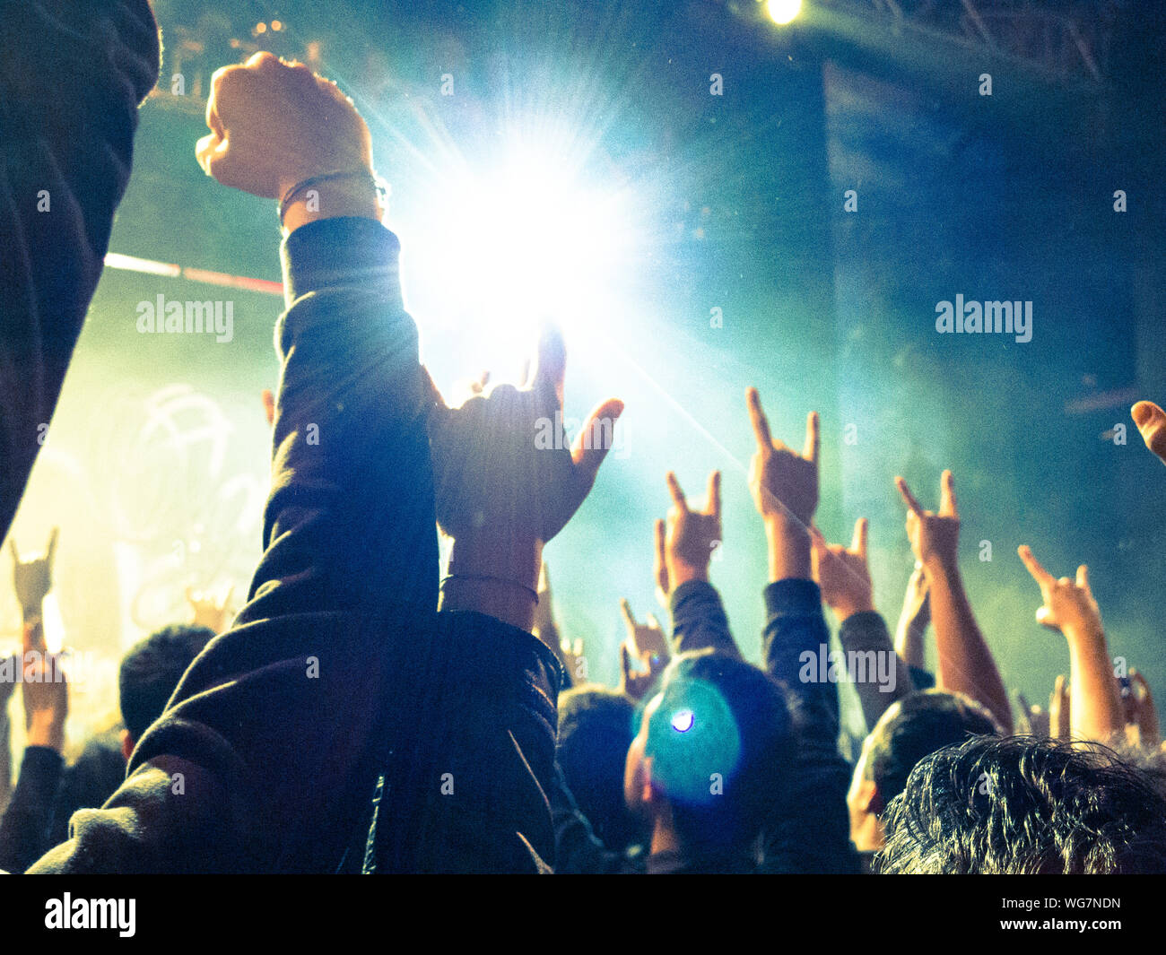 Concert crowd clapping in front of a bright stage Stock Photo - Alamy