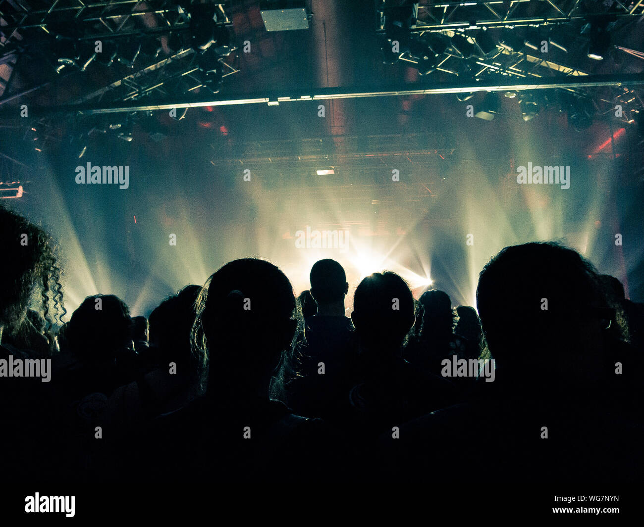 Concert crowd clapping in front of a bright stage Stock Photo - Alamy