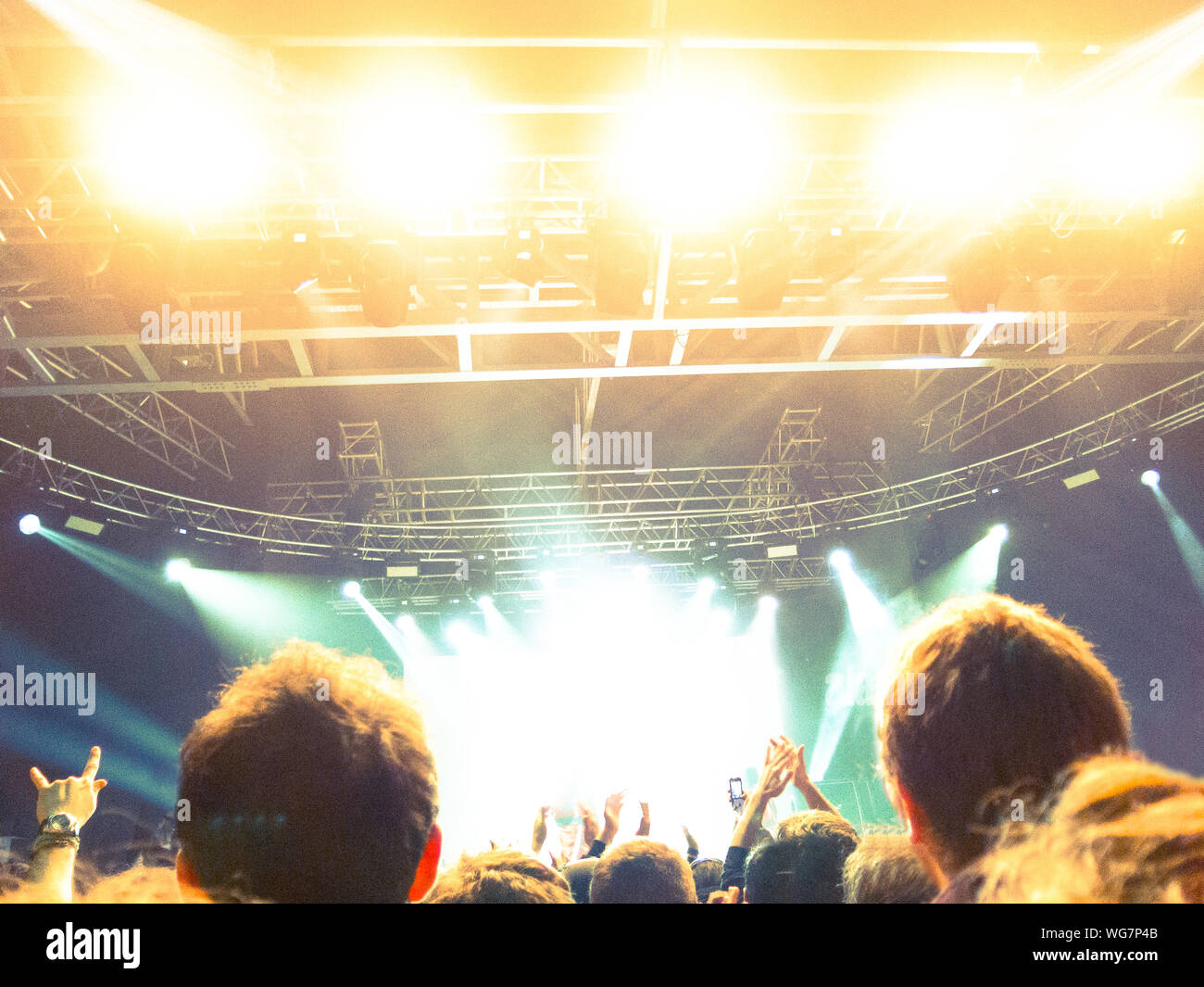 Concert crowd clapping in front of a bright stage Stock Photo - Alamy