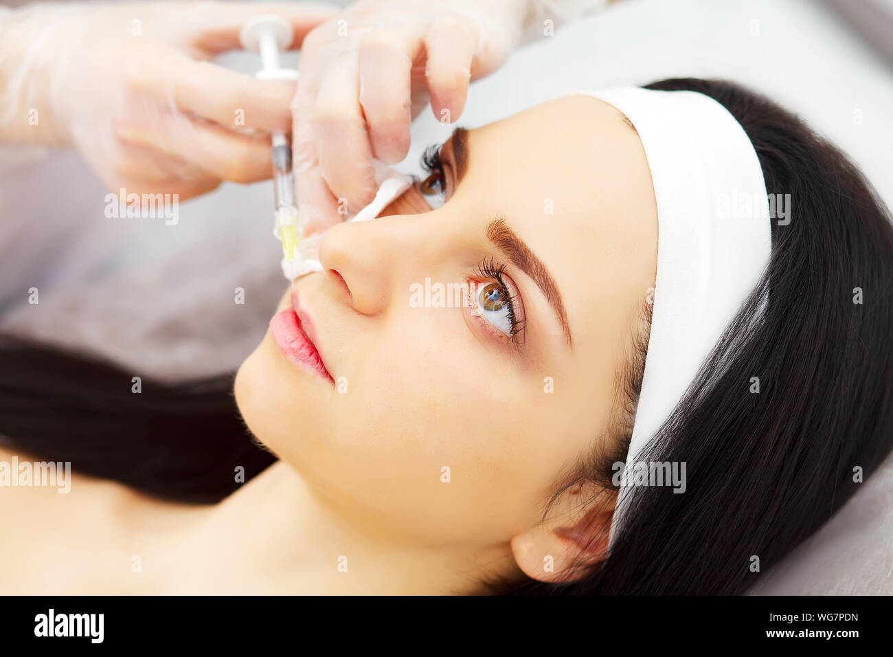 Pretty Caucasian female having of hyaluronic acid injection in face ...