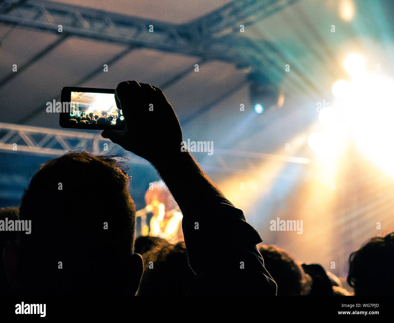 Concert crowd clapping in front of a bright stage Stock Photo - Alamy