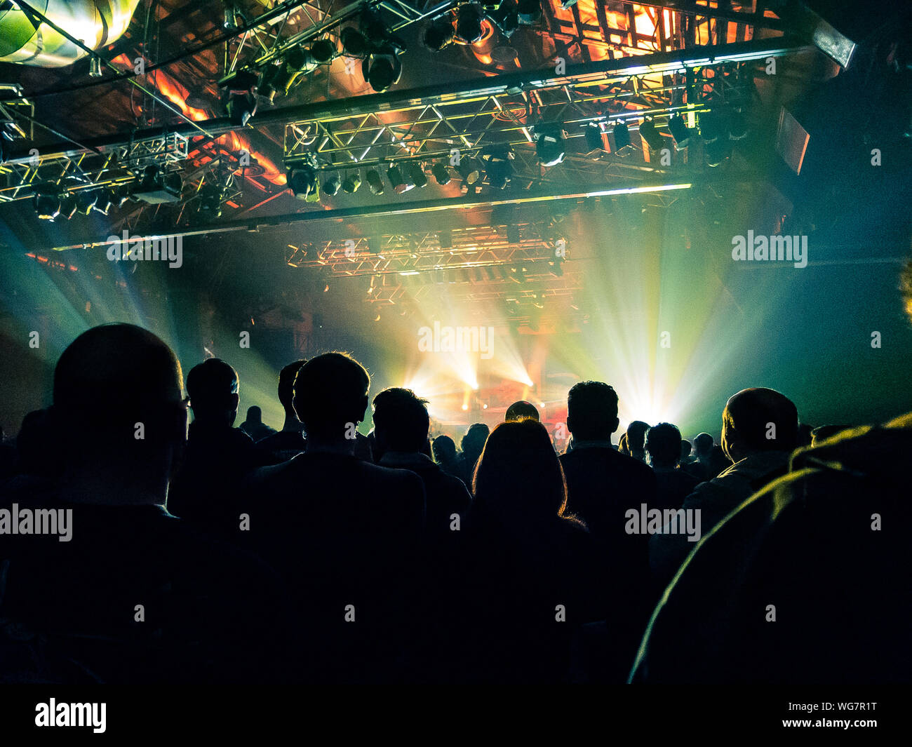 Concert crowd clapping in front of a bright stage Stock Photo - Alamy