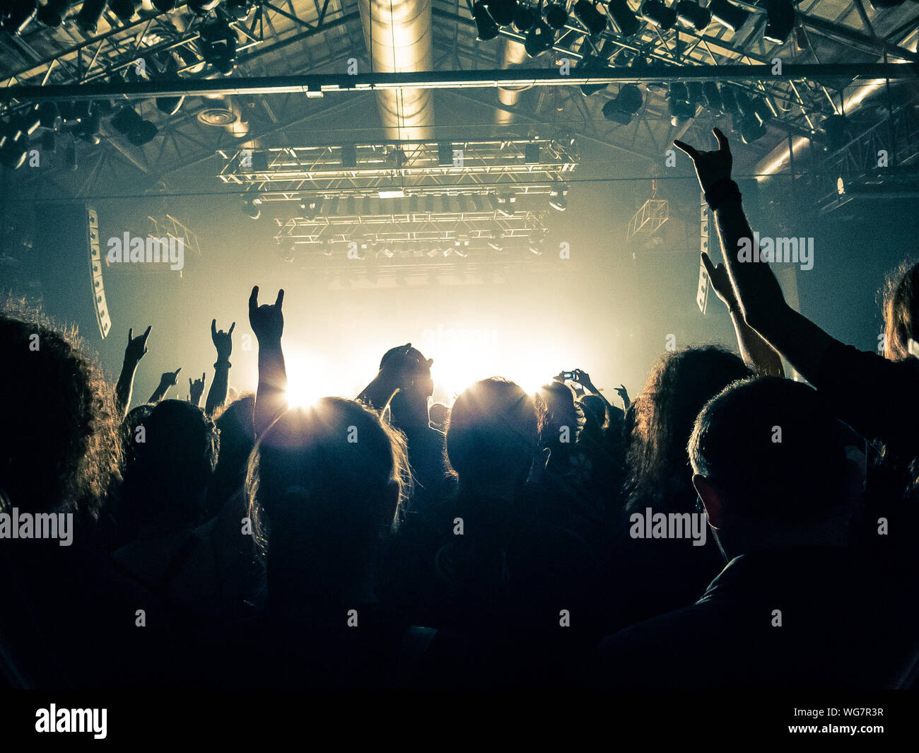 Concert crowd clapping in front of a bright stage Stock Photo - Alamy