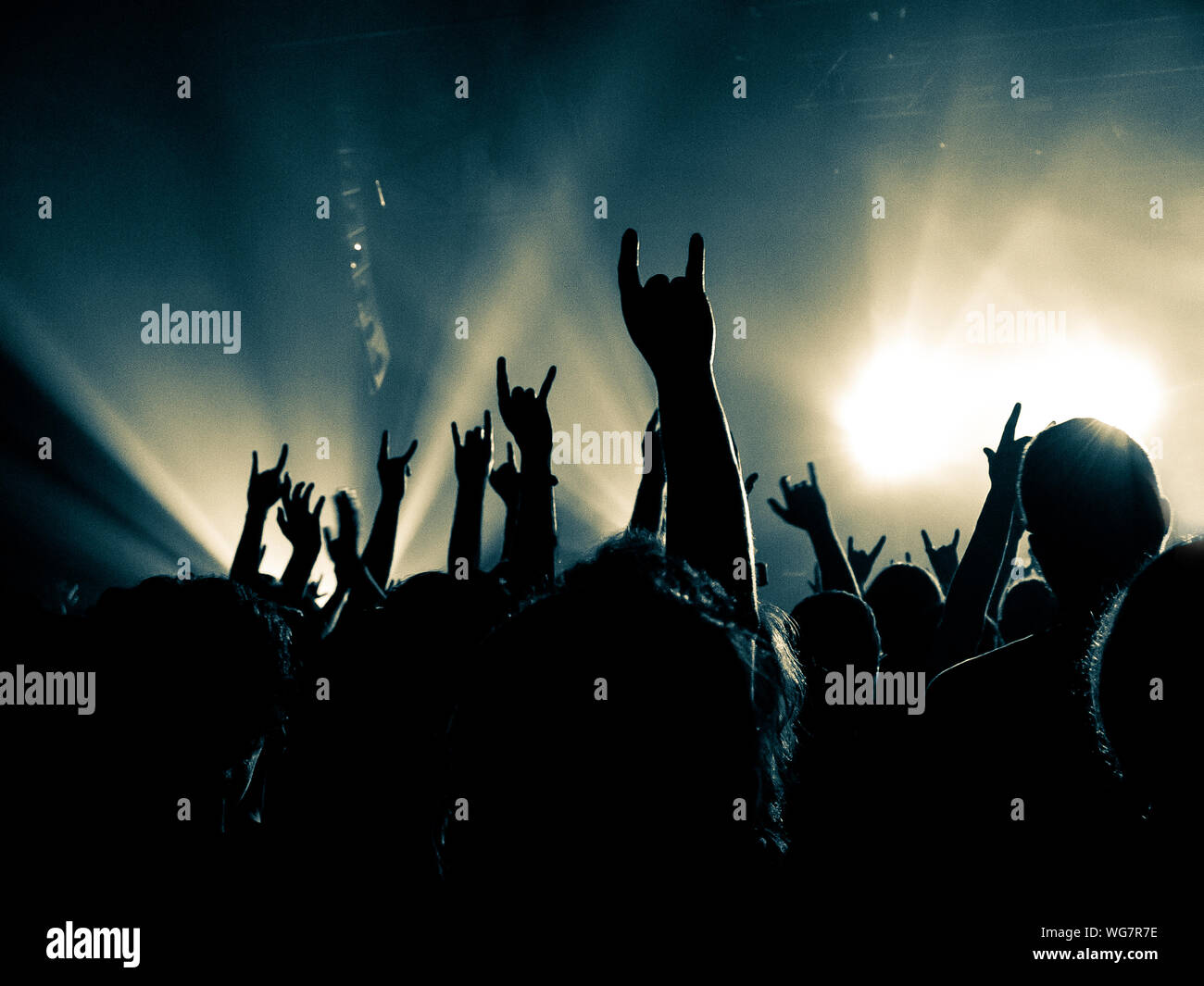 Concert crowd clapping in front of a bright stage Stock Photo - Alamy