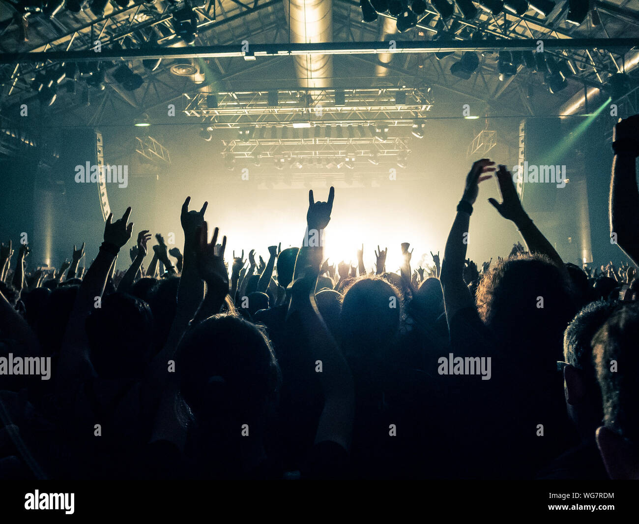 Concert crowd clapping in front of a bright stage Stock Photo - Alamy