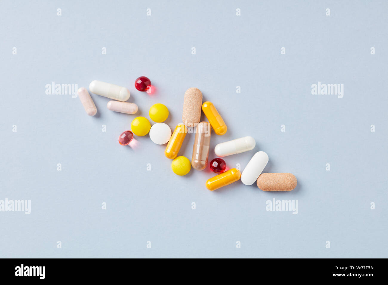 Multicolor vitamins and supplements on bright paper background. Concept ...