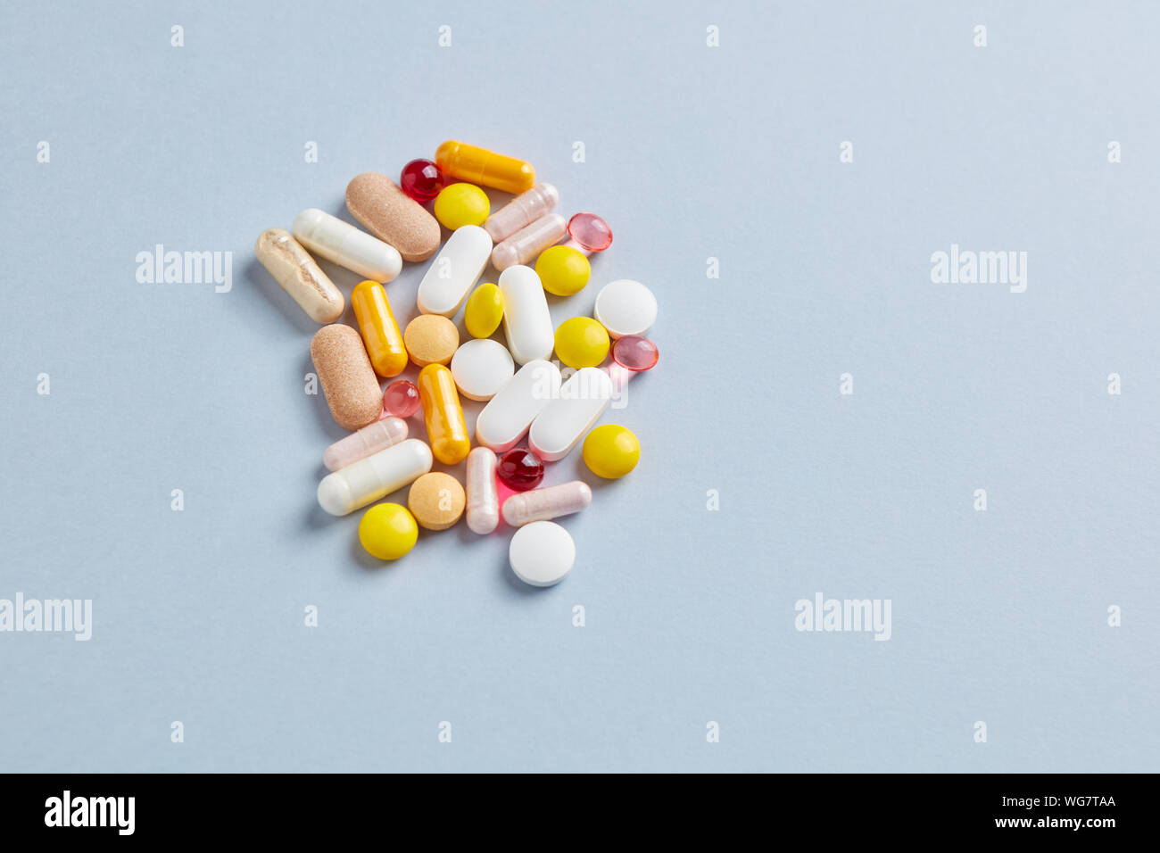 Multicolor vitamins and supplements on bright paper background. Concept ...