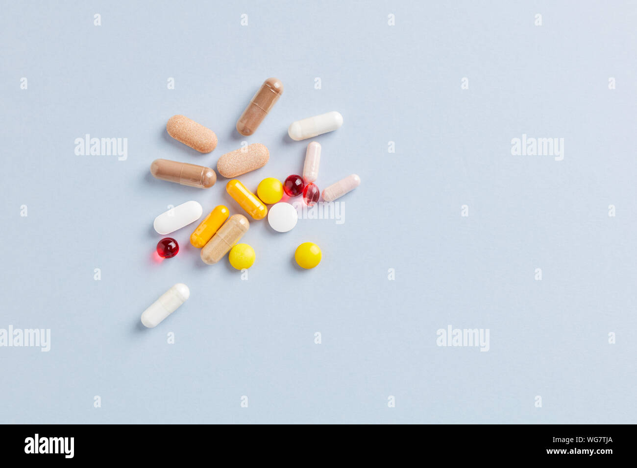 Multicolor vitamins and supplements on bright paper background. Concept ...