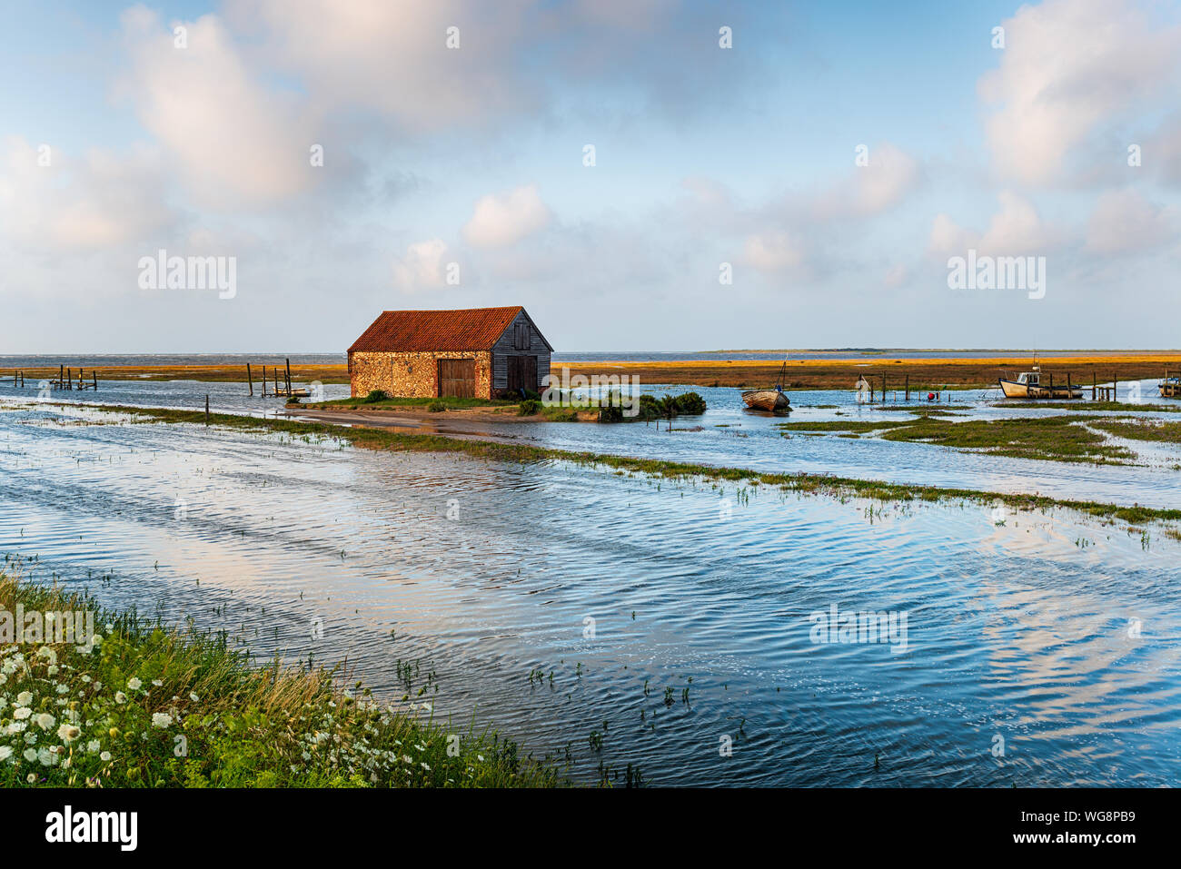 Spring tides flooding the road at the old harbour at Thornham on the ...