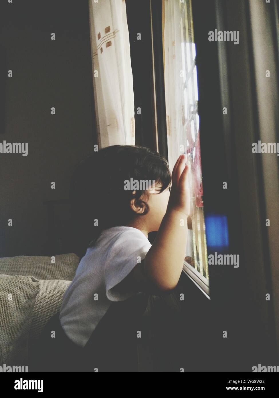 Child looking through window hi-res stock photography and images - Alamy