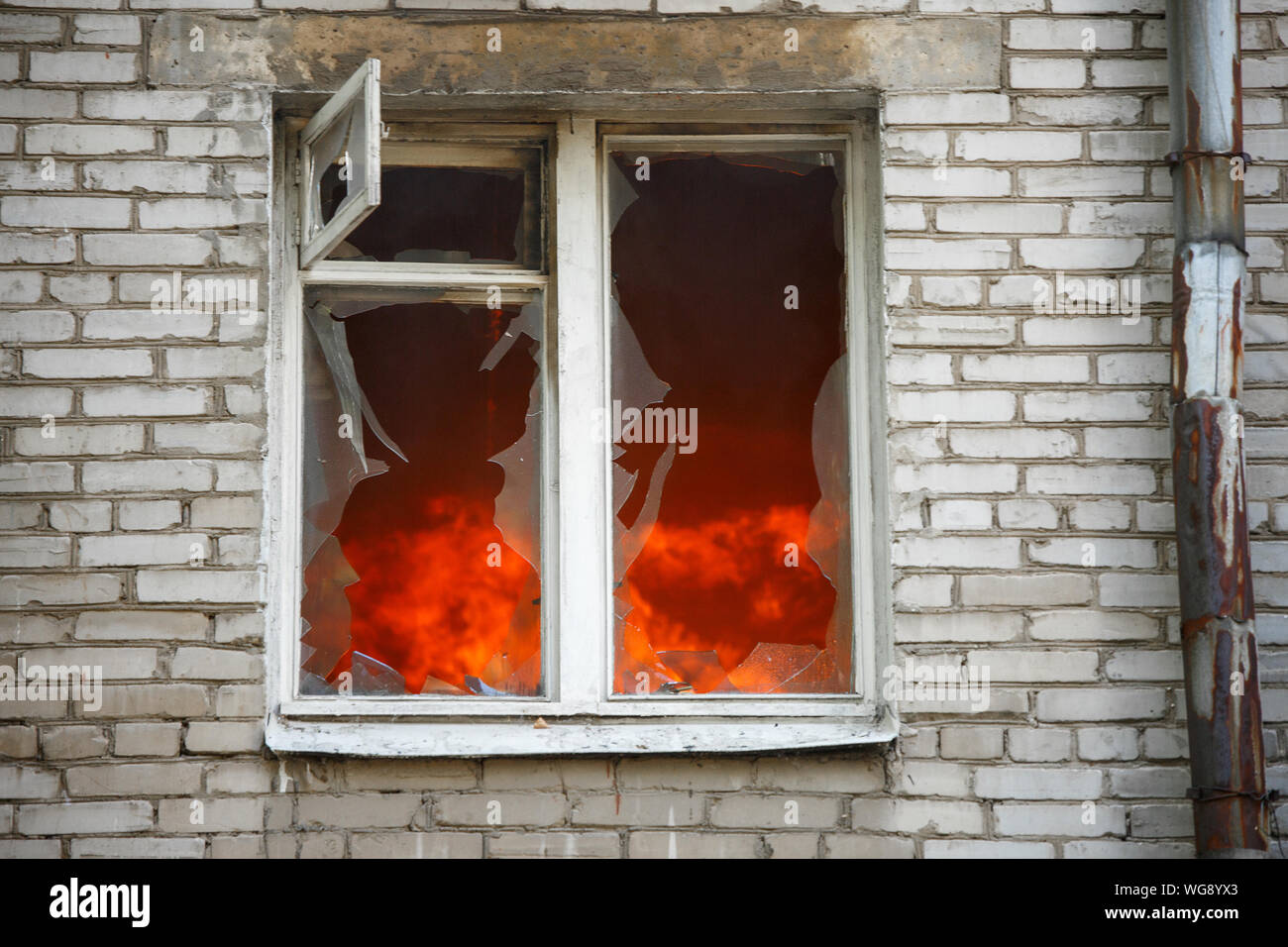 Image of brick house with with fire in window during day Stock Photo ...