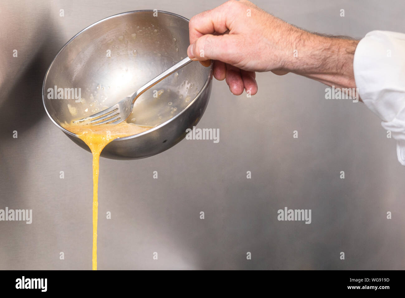Chef pouring omelette mix into a hot frying pan Stock Photo - Alamy