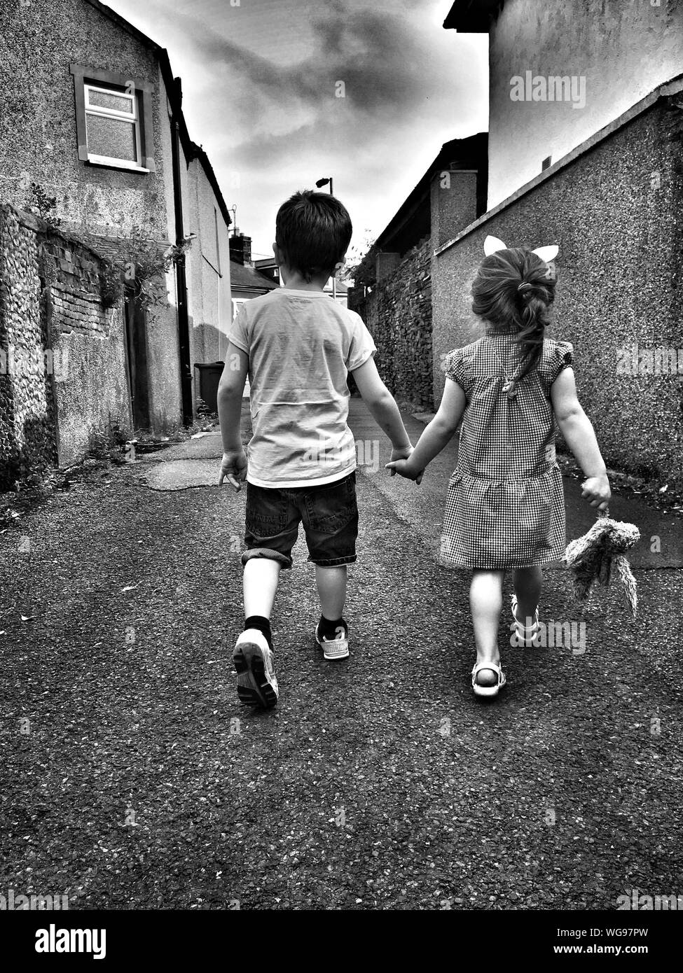 Rear View Of Children Walking On Road Stock Photo - Alamy