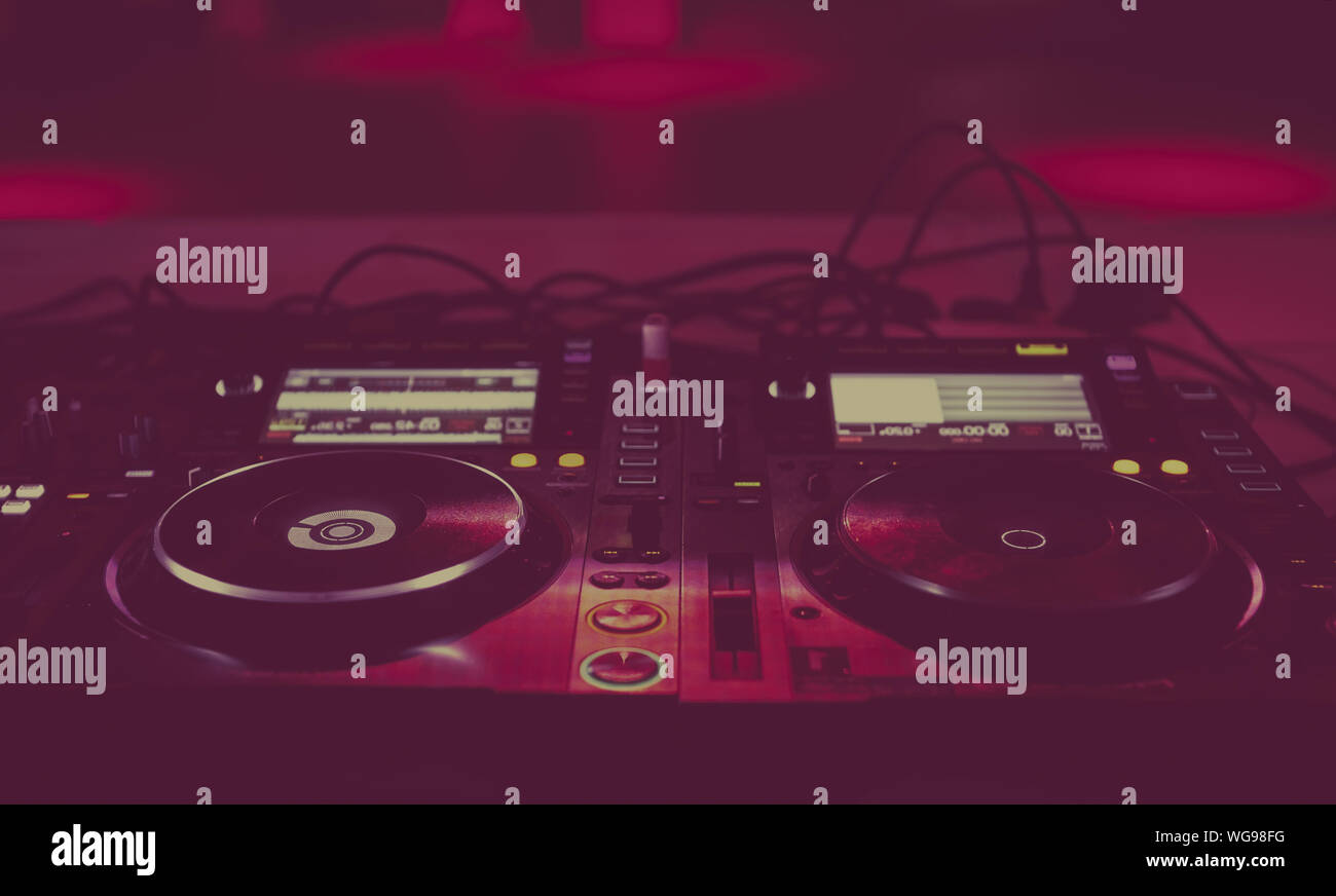 Professional dj turntables on scene in red lights.Hip hop disc jockey ...