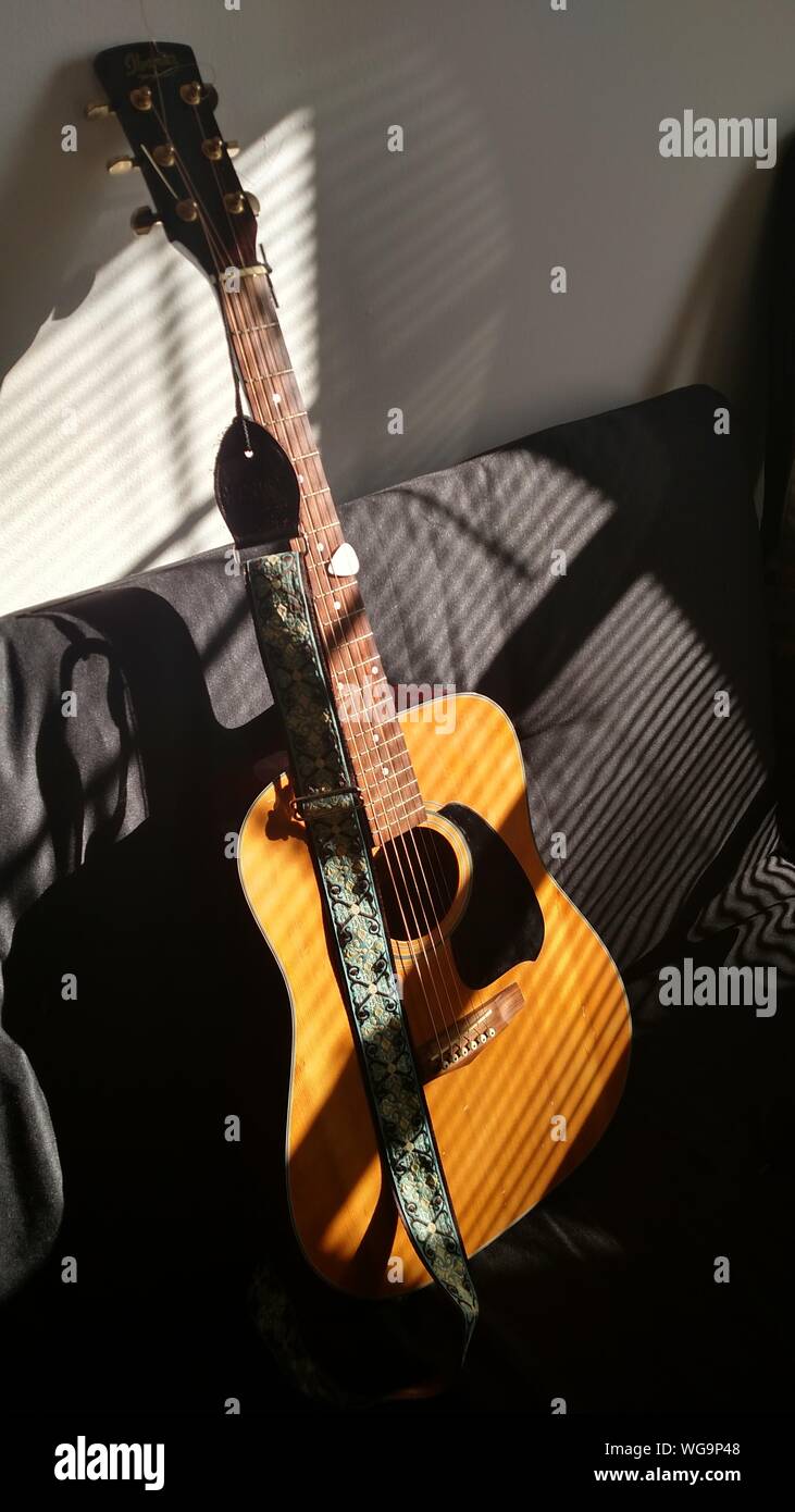 Sunlight Falling On Guitar At Sofa Stock Photo - Alamy